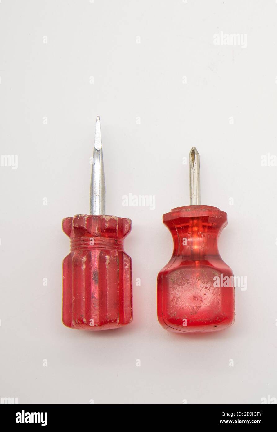 Two small screwdrivers with red handles on a white background Stock ...