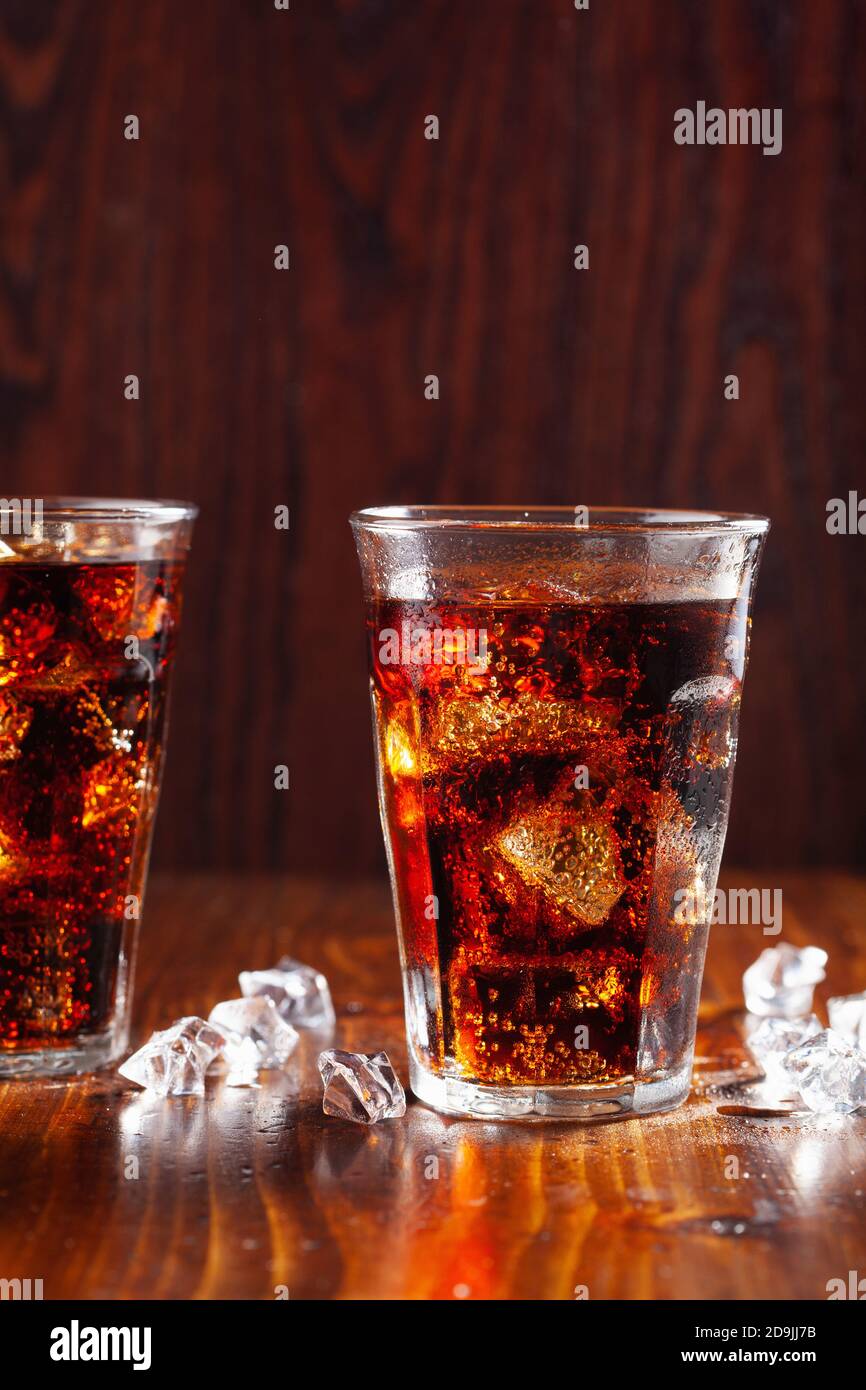 glass of cold cola soft drink with ice on wooden background Stock Photo ...