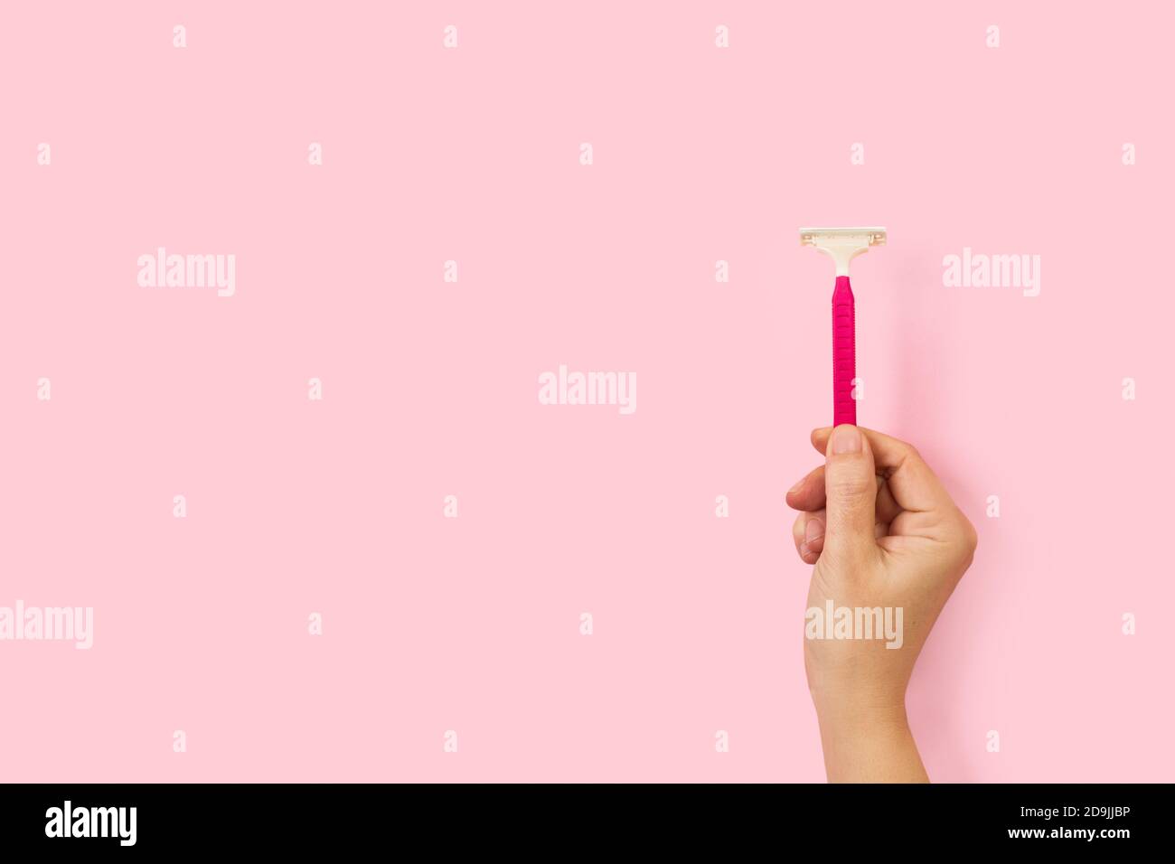 Woman hand holding a razor on a pink background with copy space Stock ...