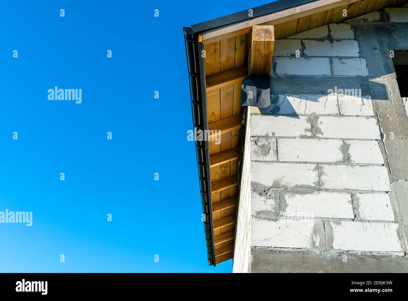 Construction of a small house made of white brick, visible gable roof ...