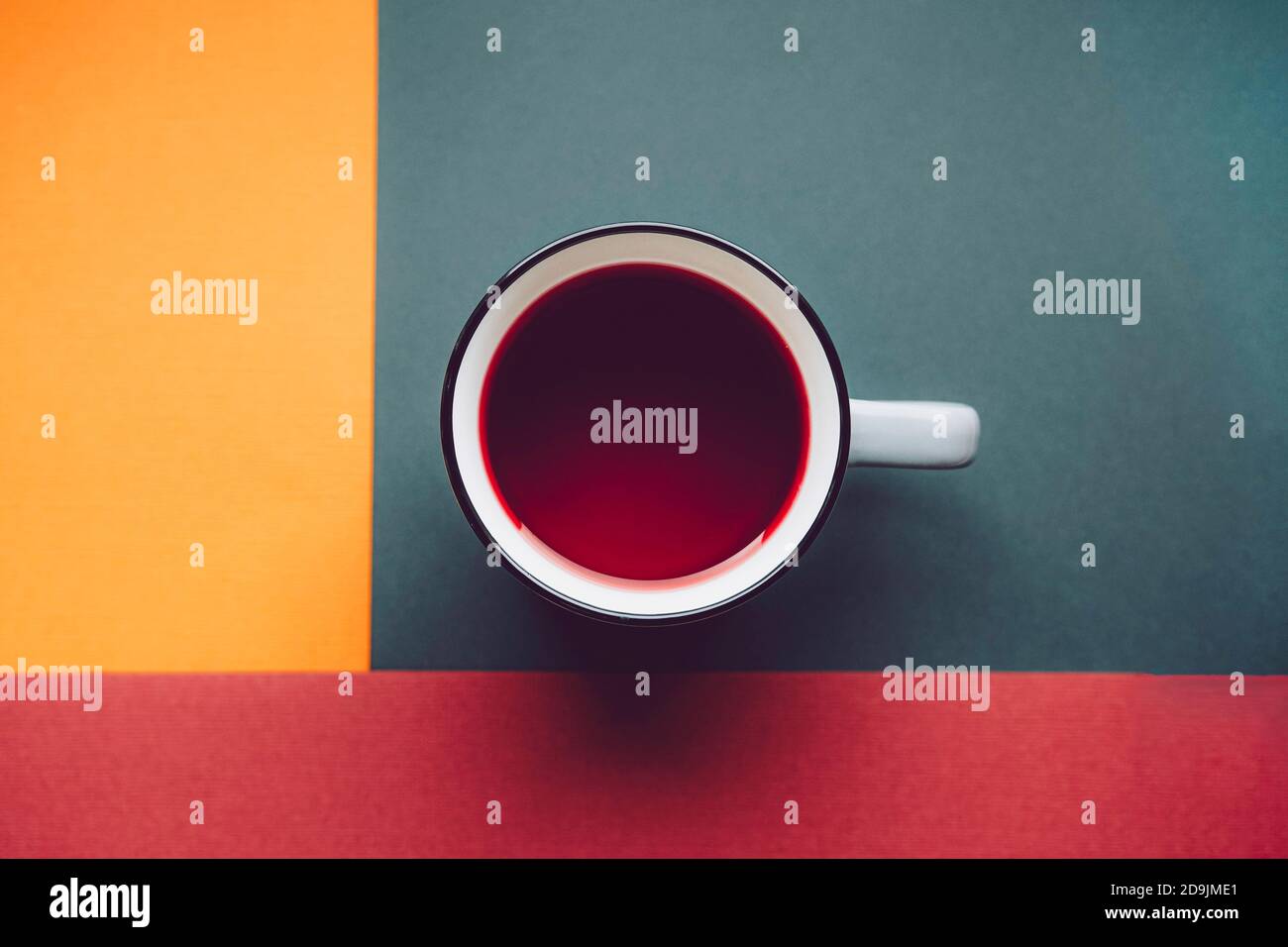 A cup of Hibiscus red tea on colorful square blank background in warm ...