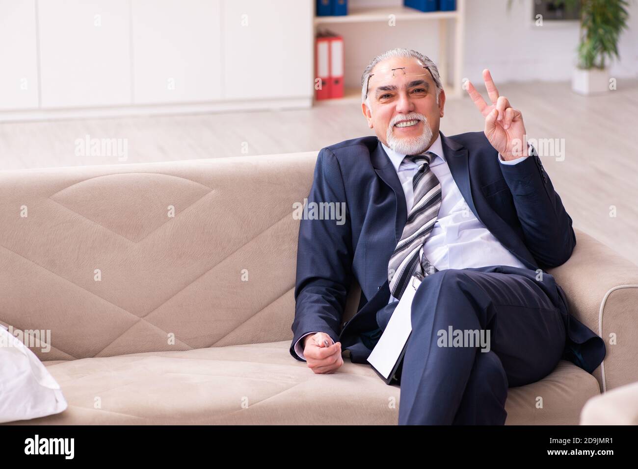 Old psychologist sitting on the sofa Stock Photo - Alamy