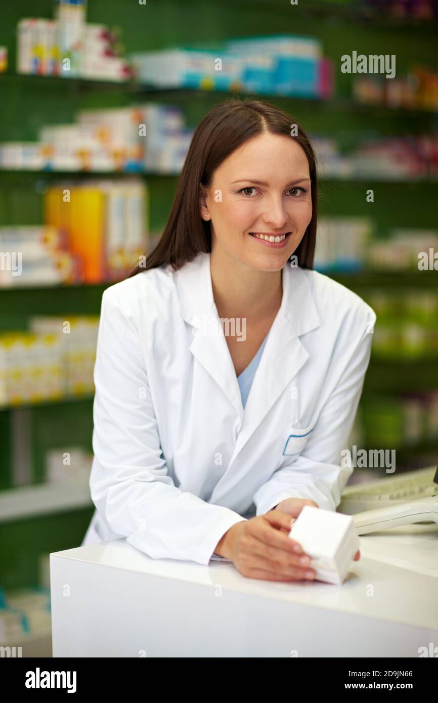 Laughing pharmacist stands in pharmacy with medicine in hand Stock ...