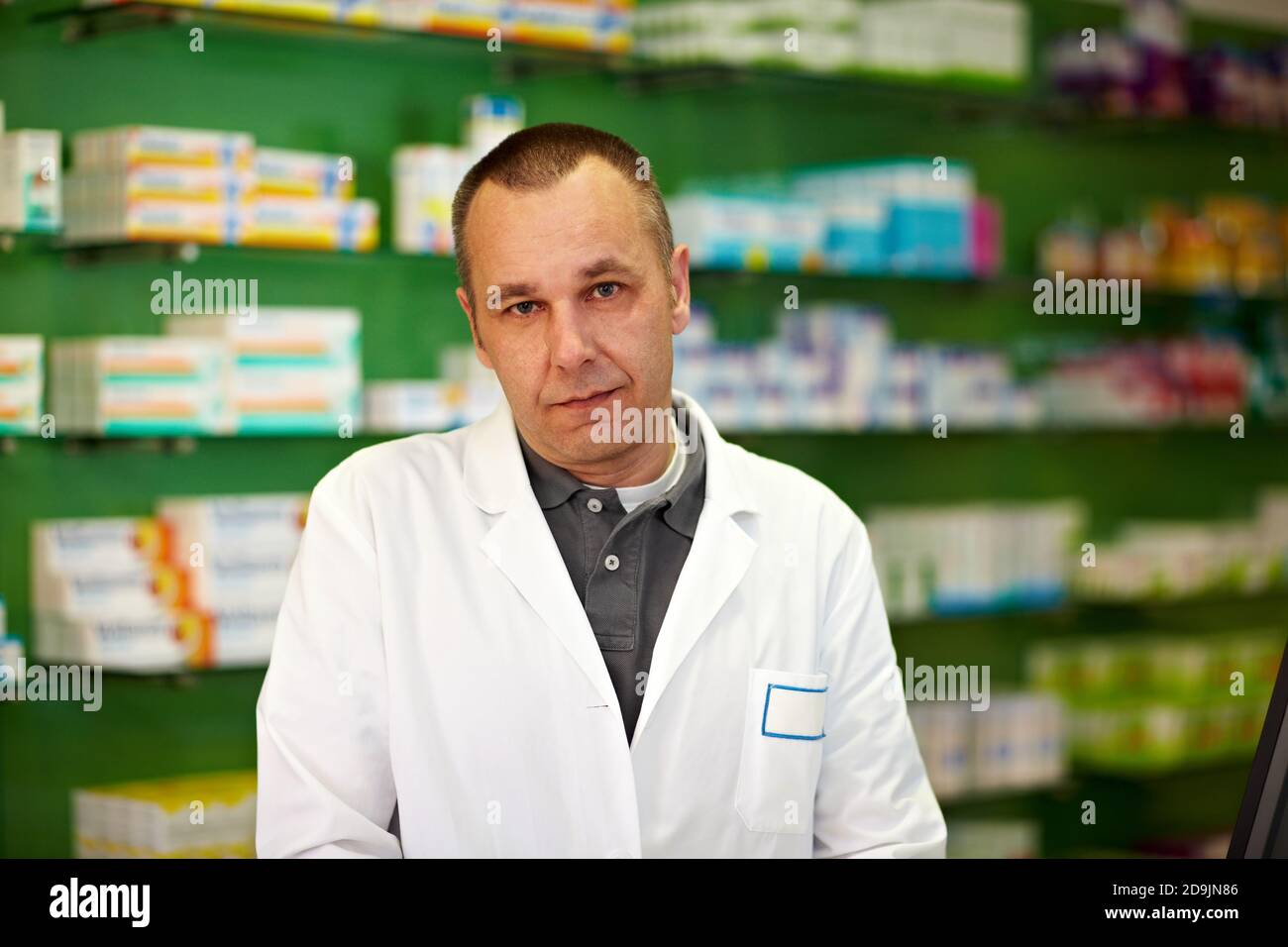 Critical pharmacist in a pharmacy looks thoughtful Stock Photo - Alamy