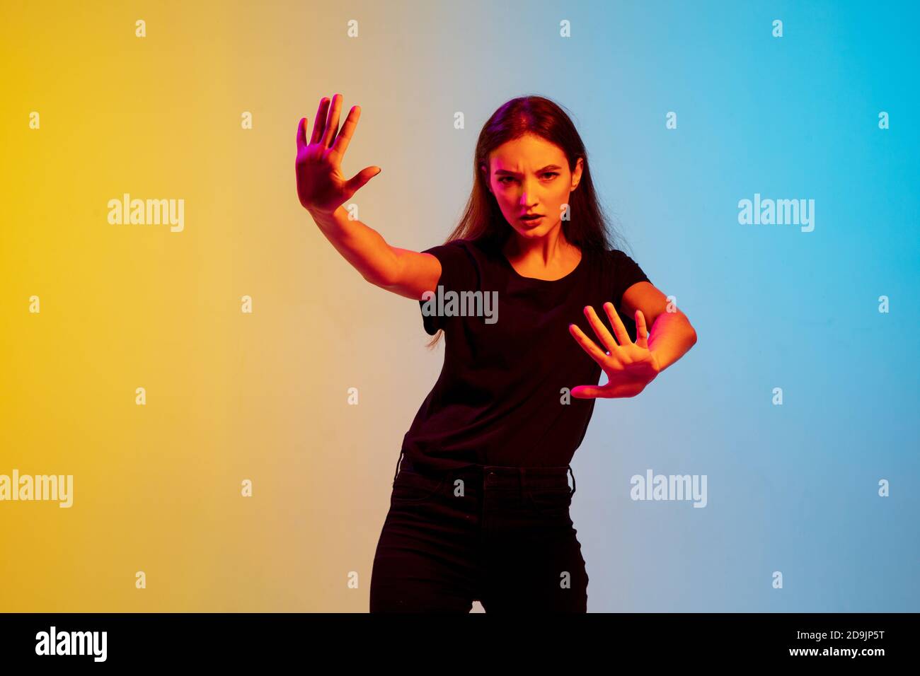 Stopping. Young caucasian woman's portrait on gradient blue-yellow ...