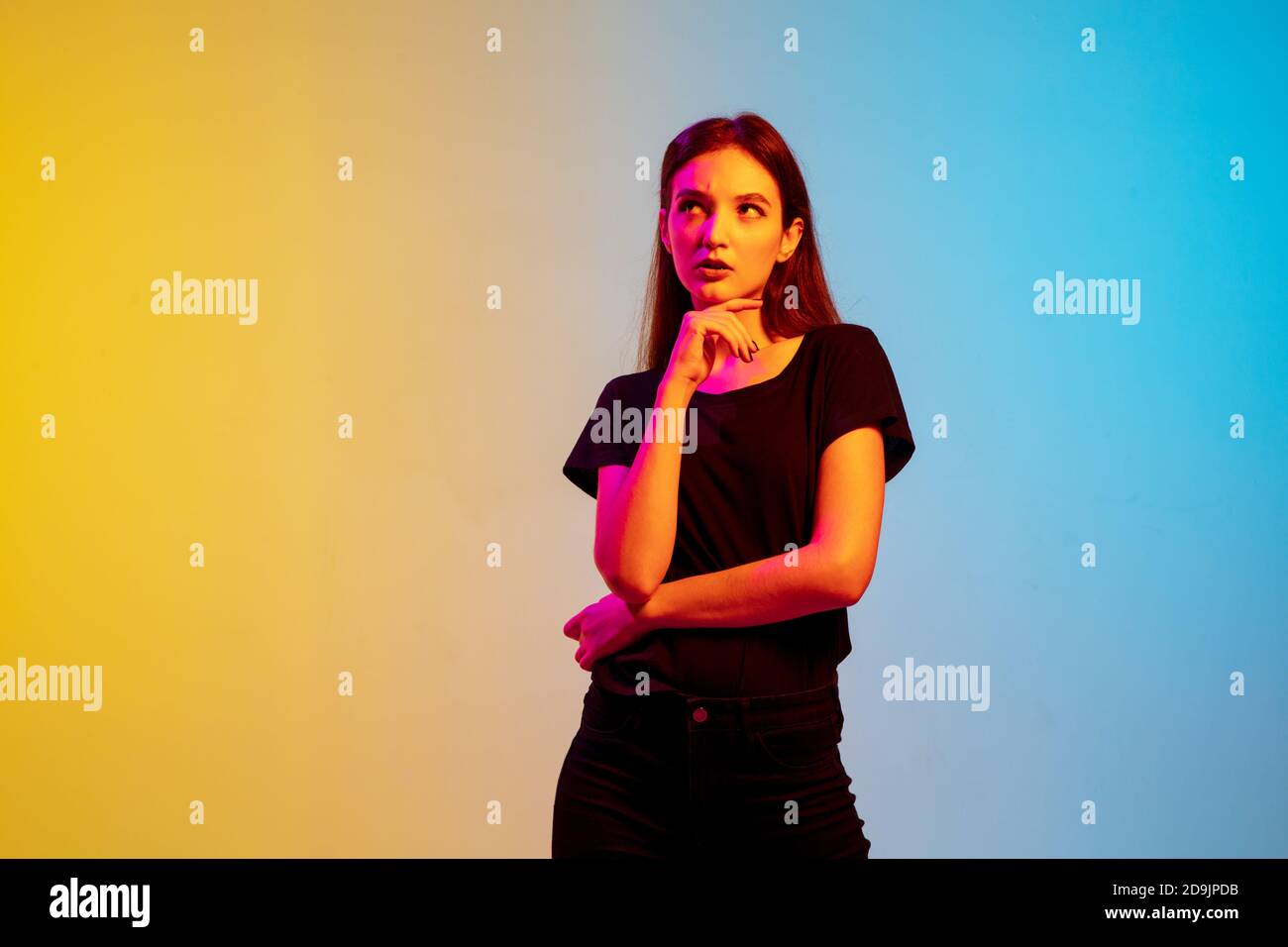 Thoughtful, dreamful. Young caucasian woman's portrait on gradient blue ...