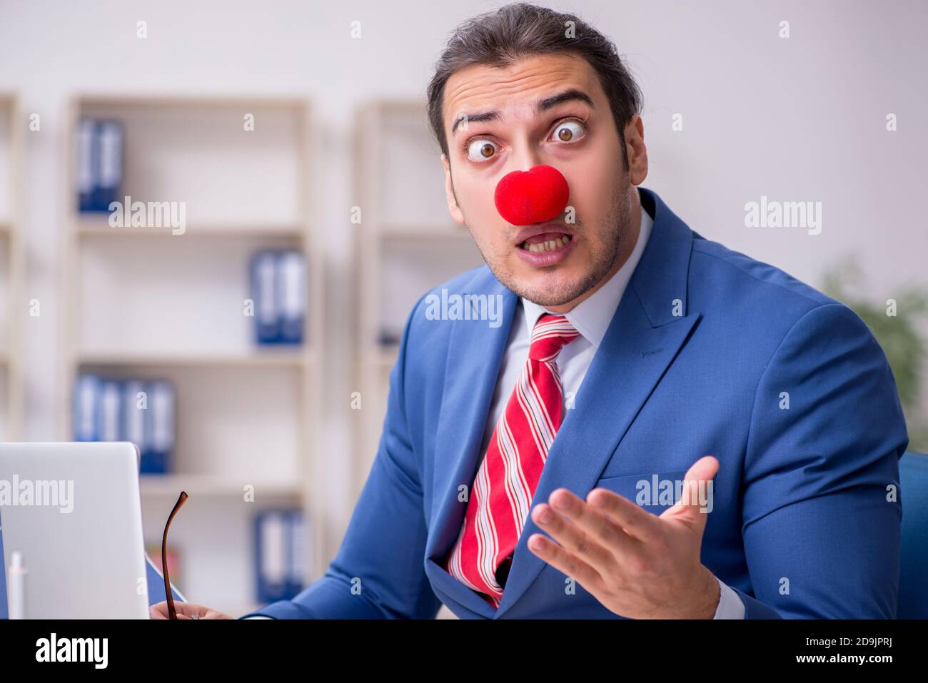 Funny employee clown working in the office room Stock Photo - Alamy