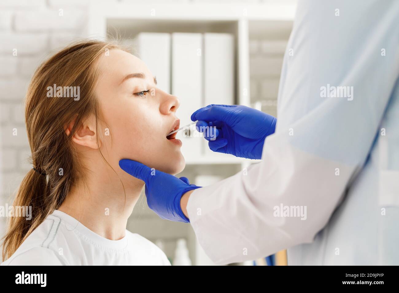 Doctor taking a throat swab from a patient woman Stock Photo - Alamy