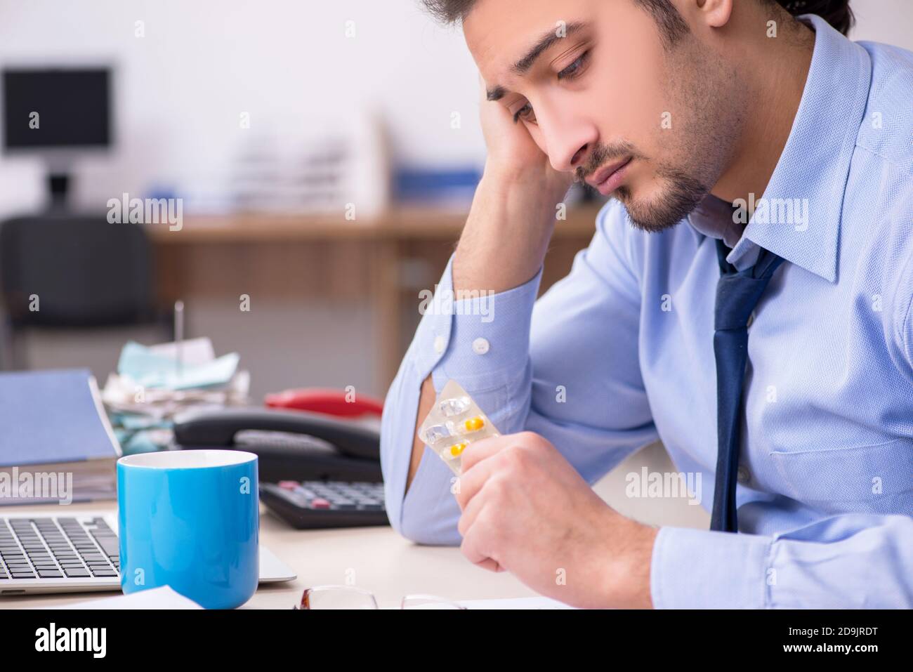 Sick male employee suffering at the workplace Stock Photo - Alamy
