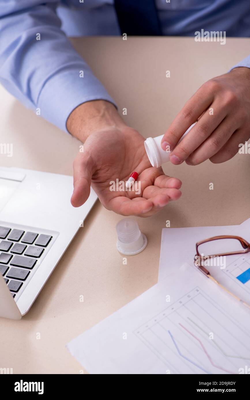 Sick male employee suffering at the workplace Stock Photo - Alamy