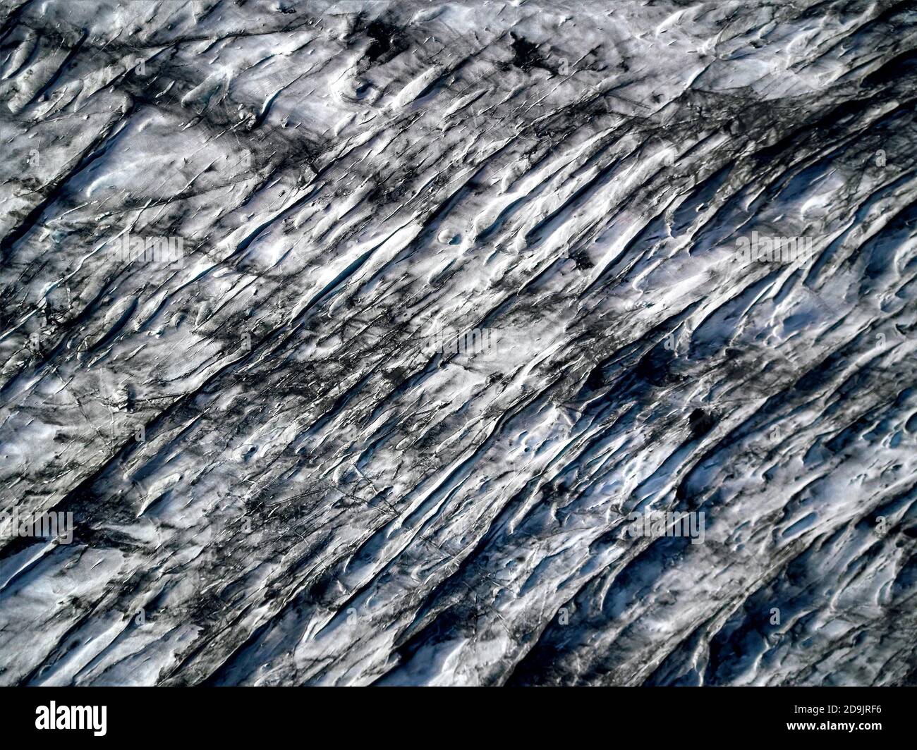 Aerial view of glacier from above, ice and ashes of the volcano texture ...