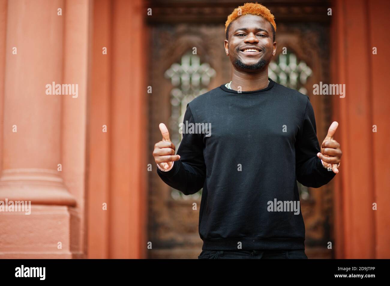 African red haired man wear black outfit posing outdoor Stock Photo - Alamy