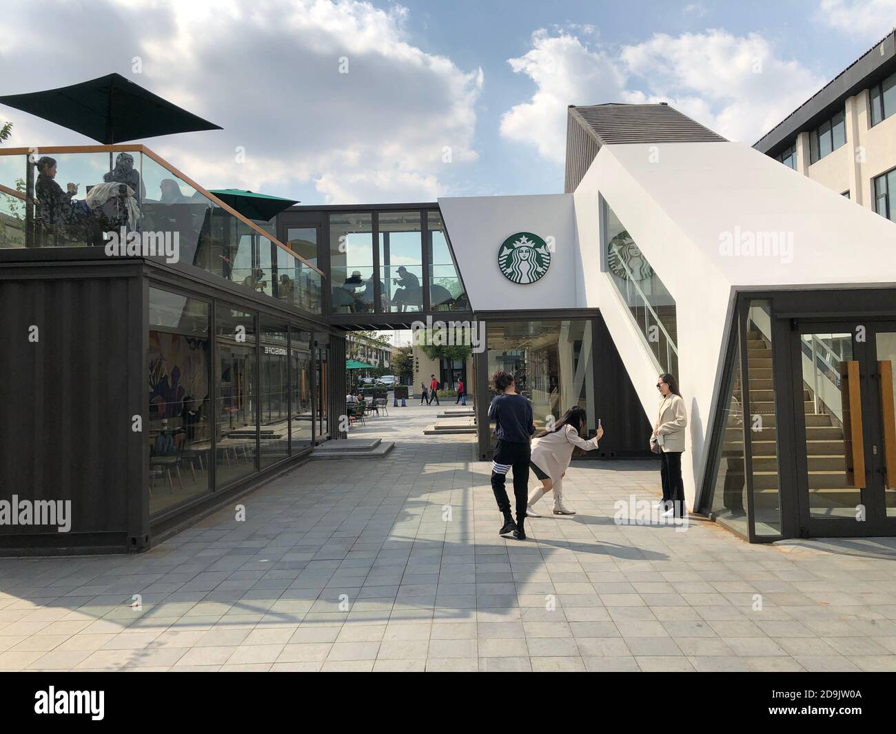 People pose for photos with the first Starbucks Container Concept Store ...