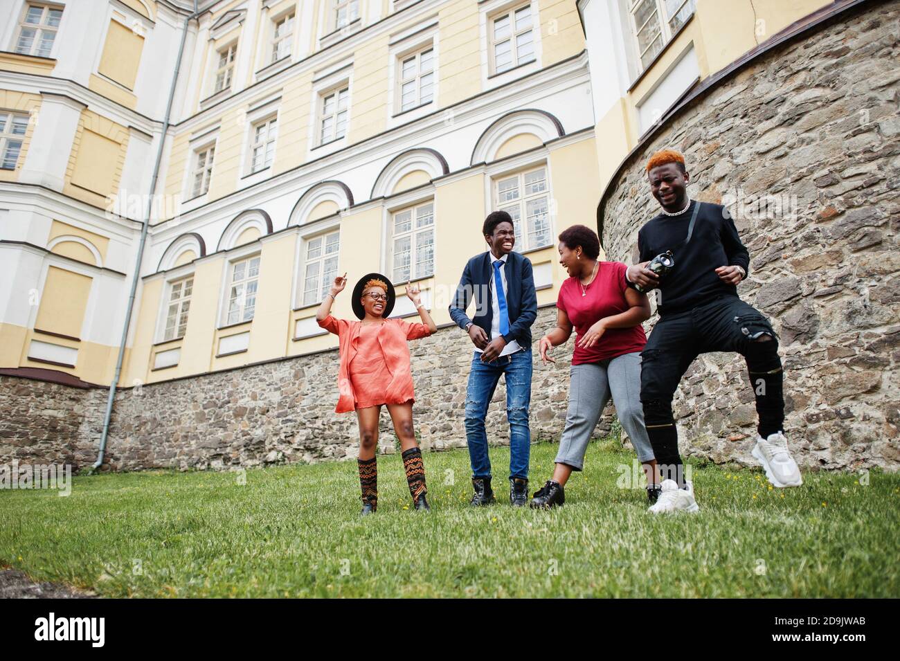 Four african friends having fun and dancing outdoors. Two black girls ...
