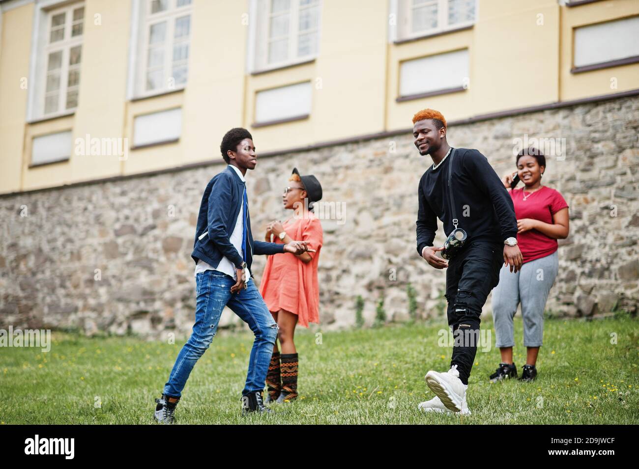 Four african friends having fun and dancing outdoors. Two black girls ...