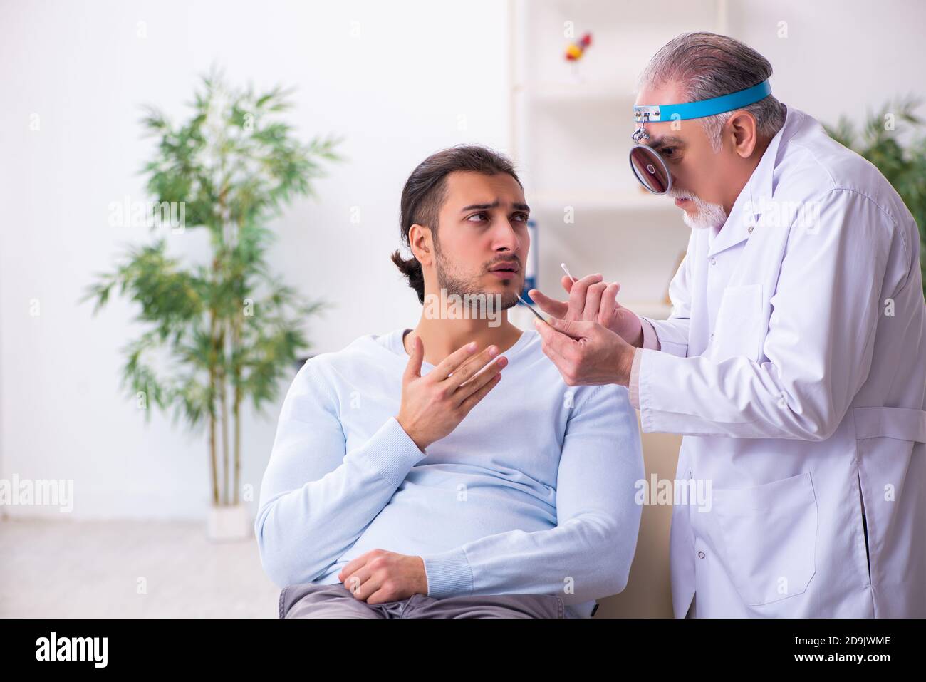 Sick man visiting old doctor otolaryngologist Stock Photo - Alamy