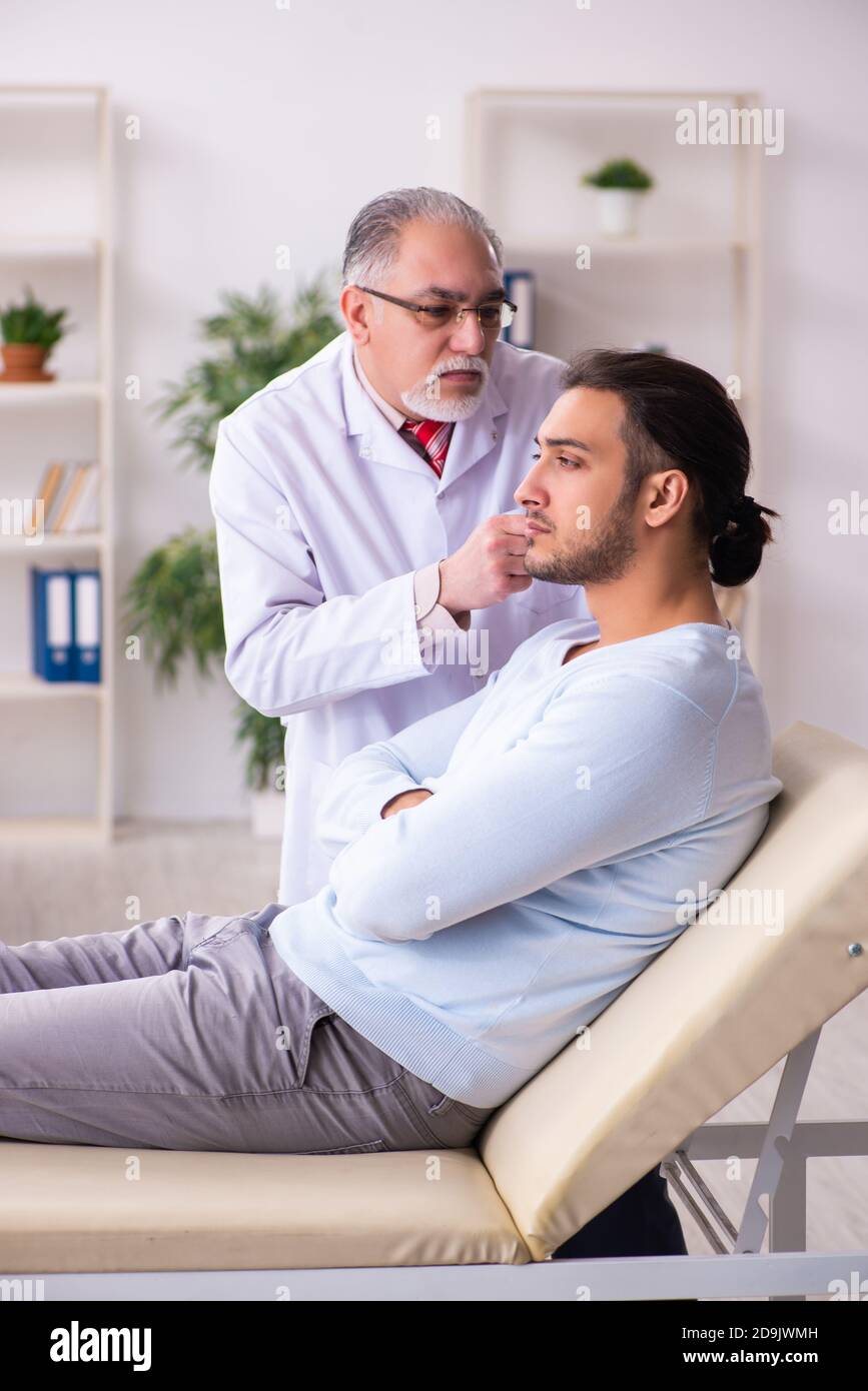 Sick man visiting old doctor otolaryngologist Stock Photo - Alamy
