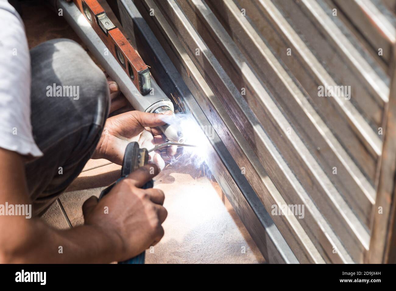 Closeup of worker welding auto gate arm onto metal gate Stock Photo - Alamy