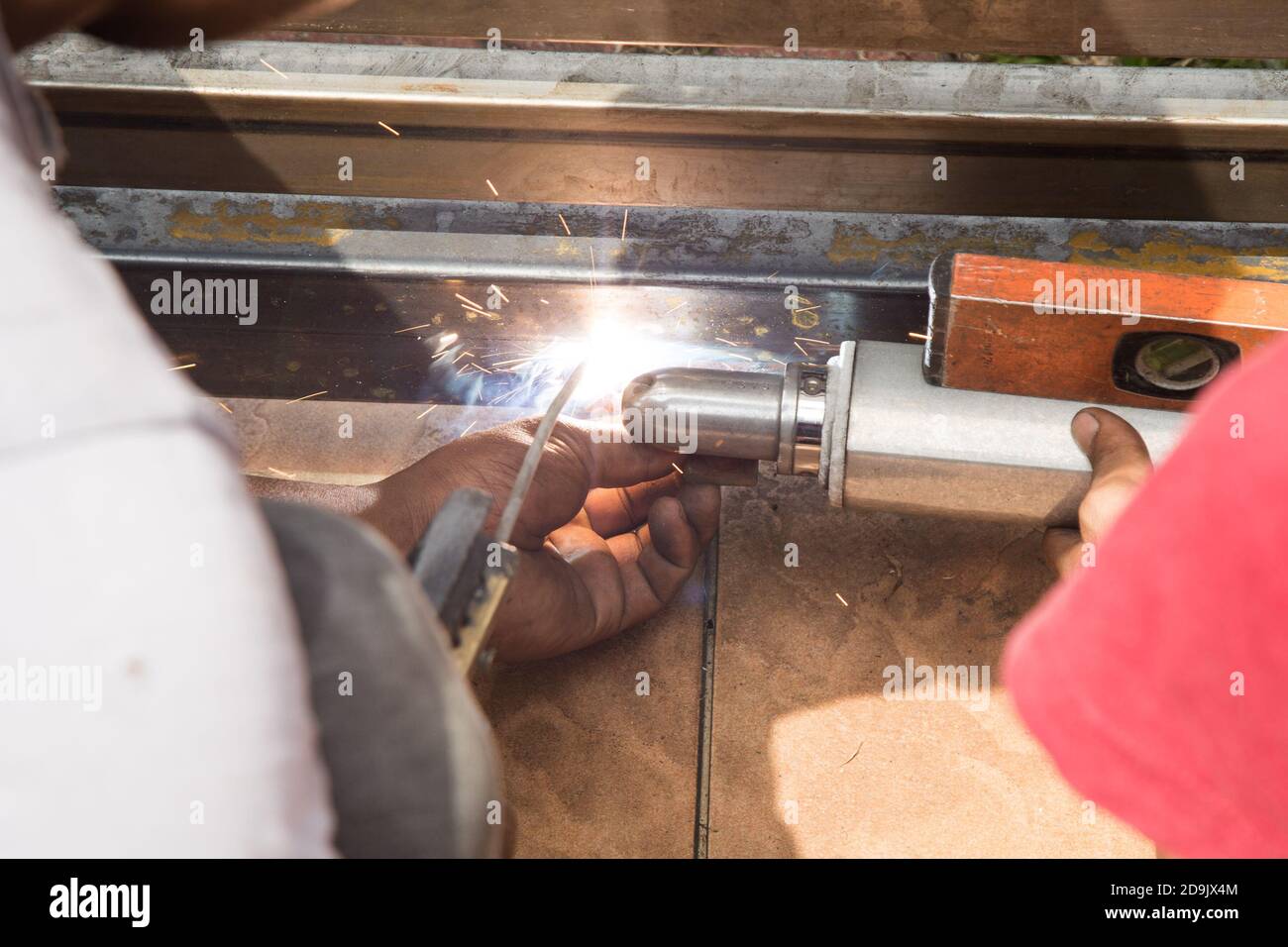 Closeup of worker welding auto gate arm onto metal gate Stock Photo - Alamy