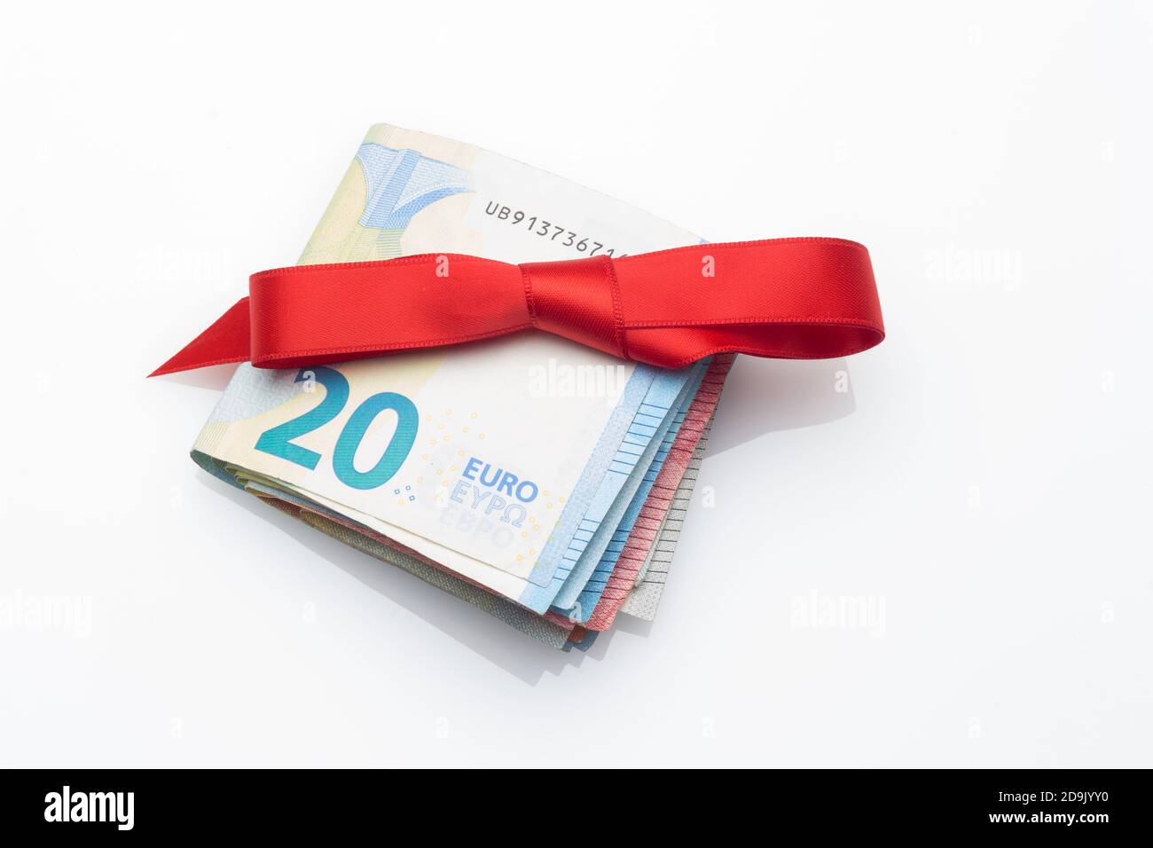 Euro notes and coins decorated with gift bows; give away money at ...