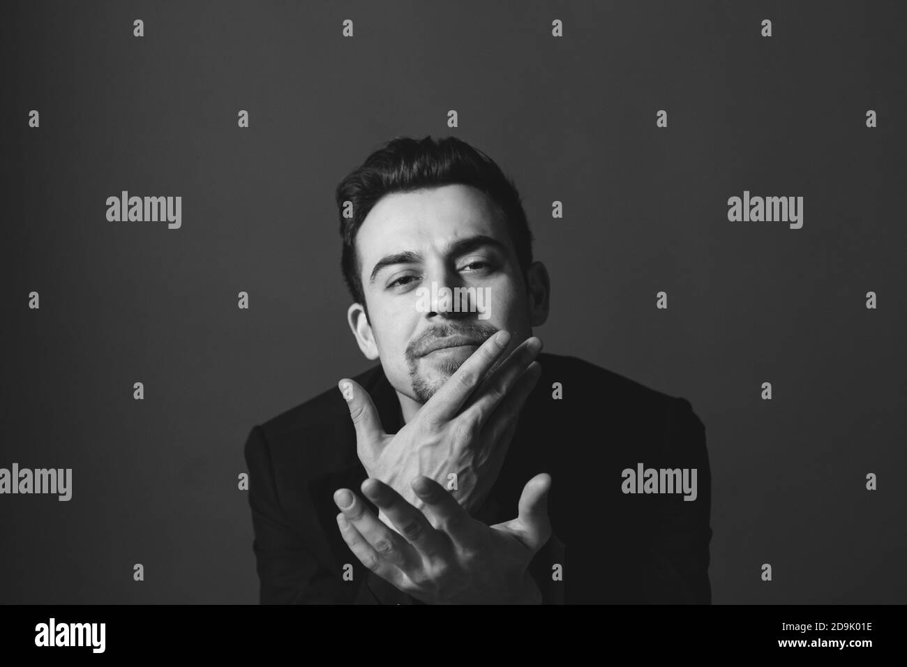 Studio portrait of a young caucasian man in a black jacket, looking at ...