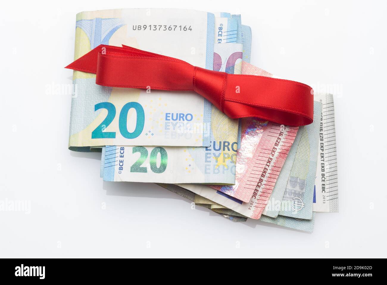 Euro notes and coins decorated with gift bows; give away money at ...