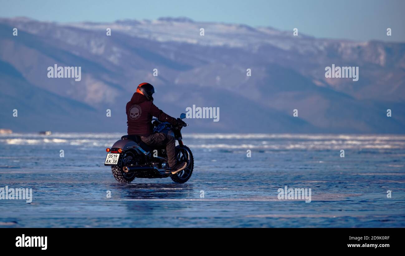 Biker riding on motorcycle Harley Davidson on a frozen lake. 03.08.2019 ...