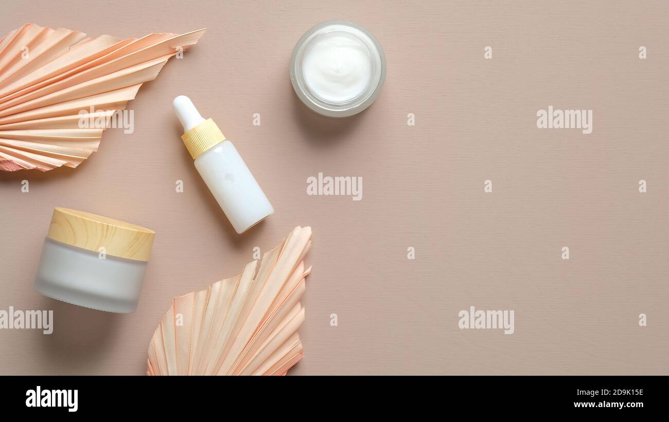 Serum lotion and natural moisturizer creams with dry flower leaves on ...