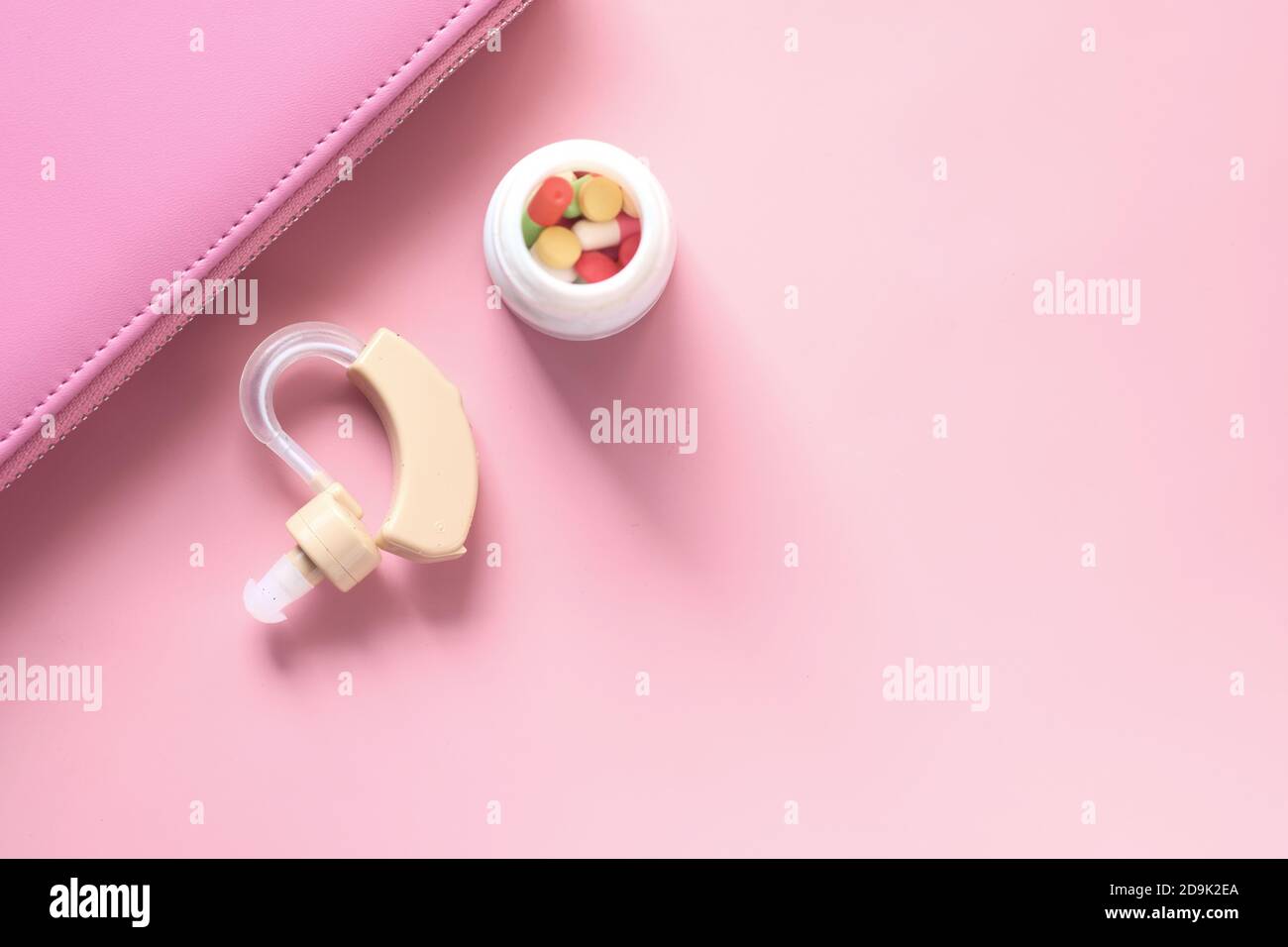 Hearing aid equipment on pink background Stock Photo - Alamy