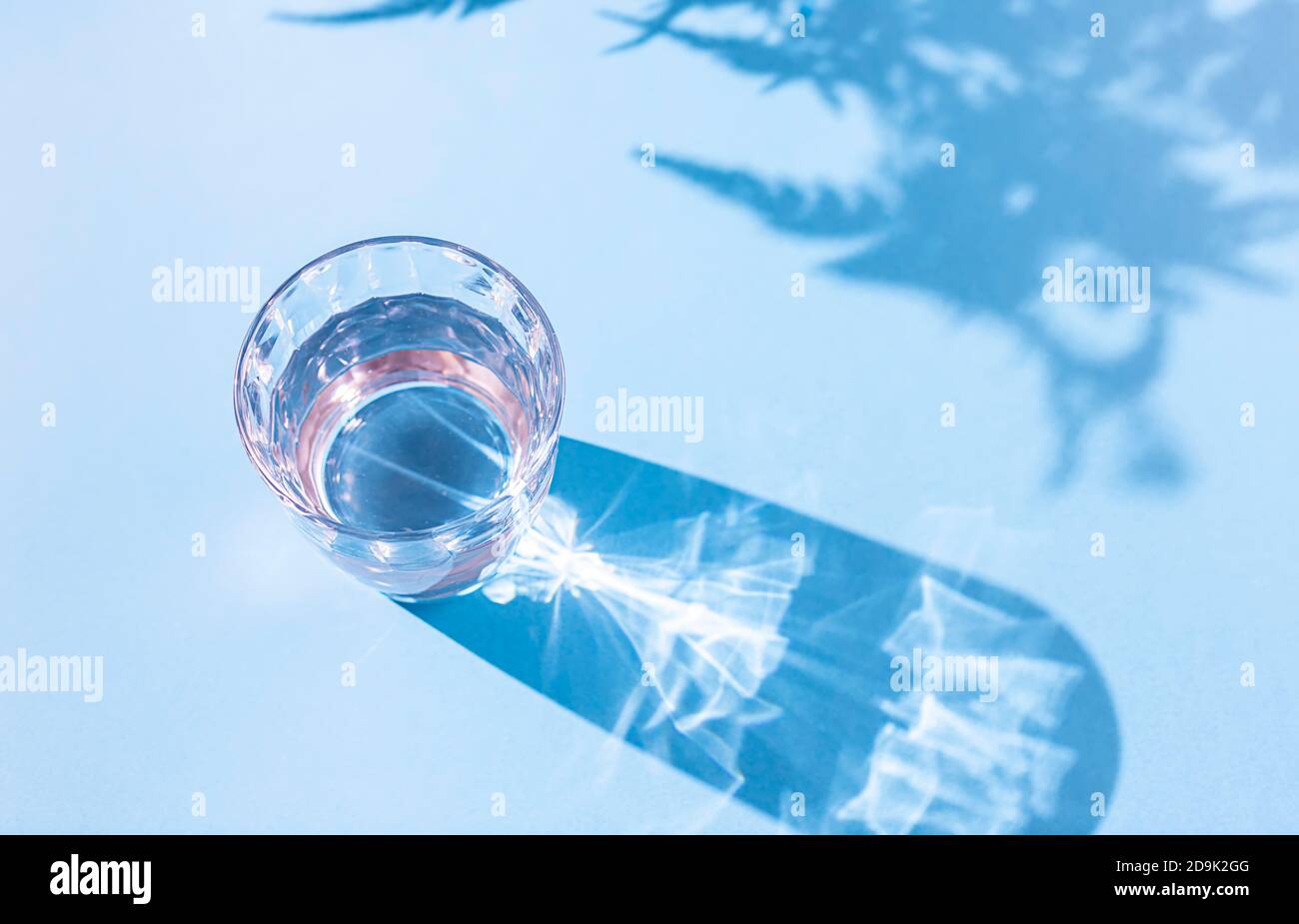 Glass of clean transparent water on a light background in natural light ...