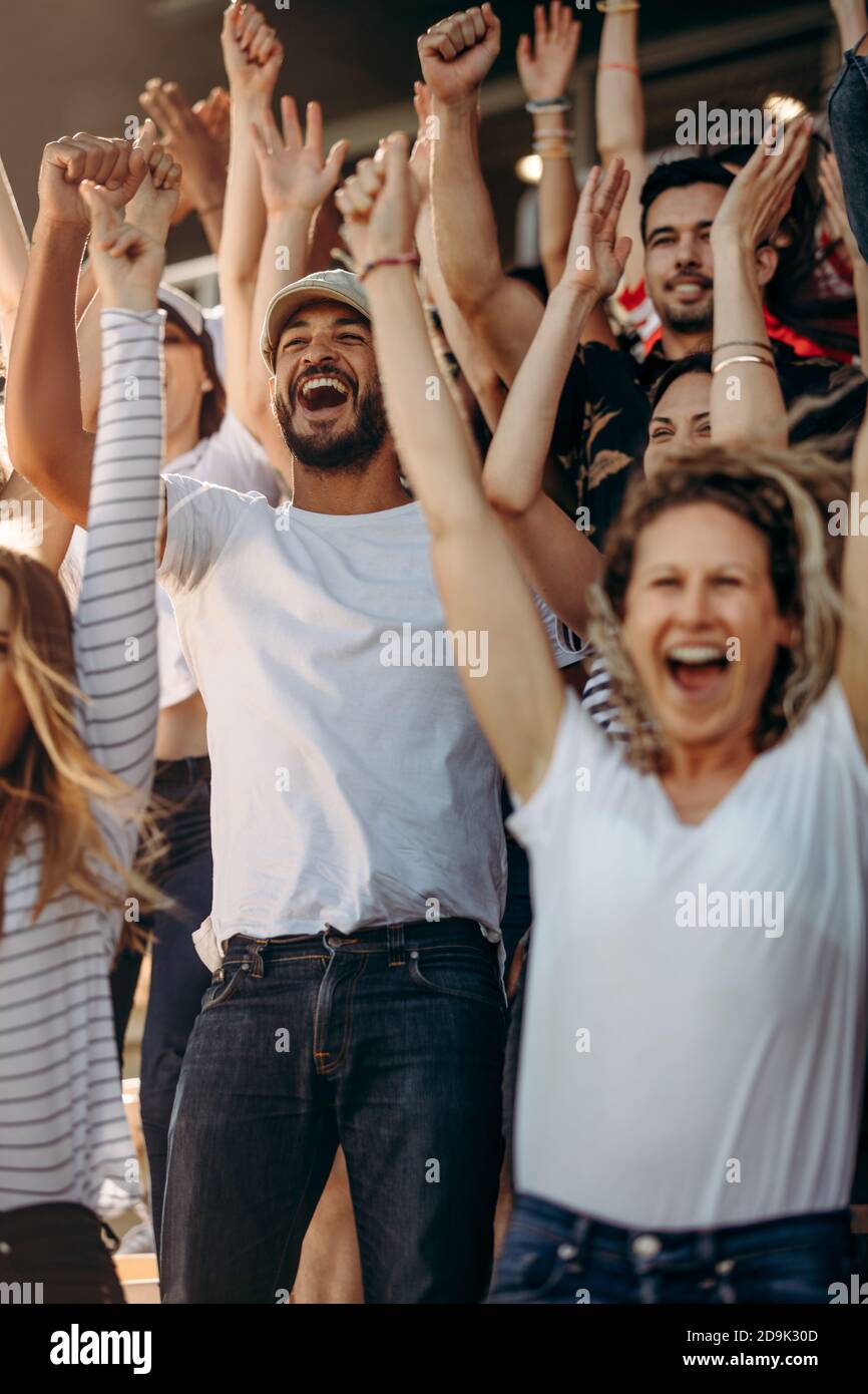 Excited sports fans at live game chanting and cheering for their team ...