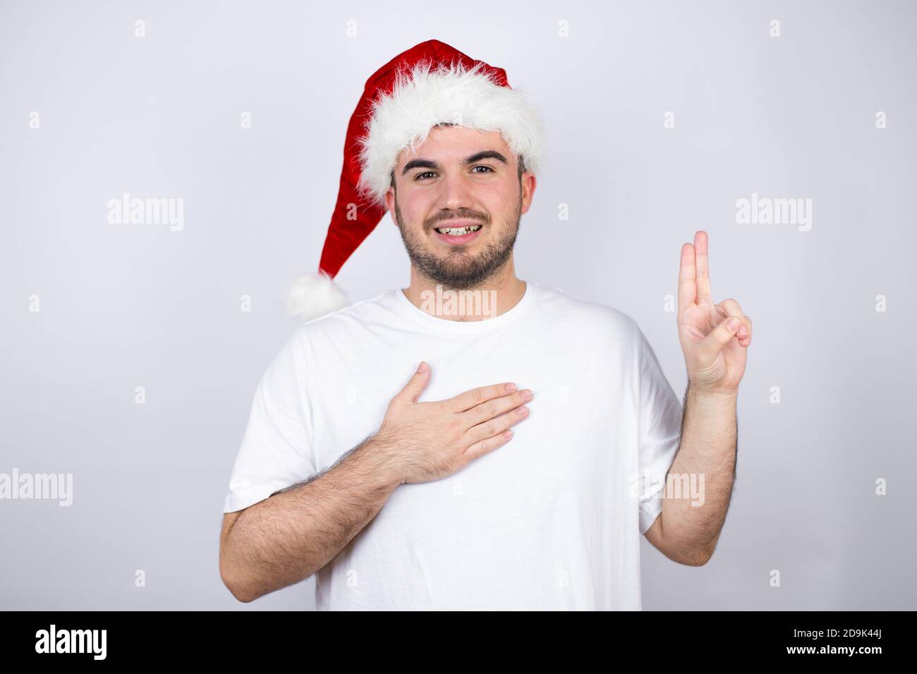 Young handsome man wearing a Santa hat over white background smiling ...
