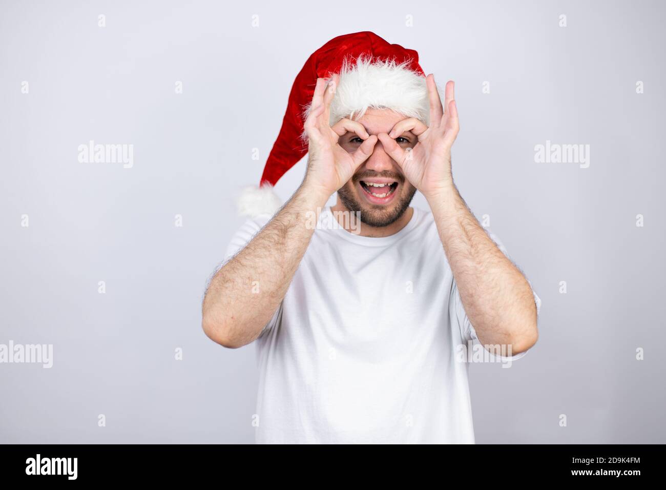 Young handsome man wearing a Santa hat over white background doing ok ...