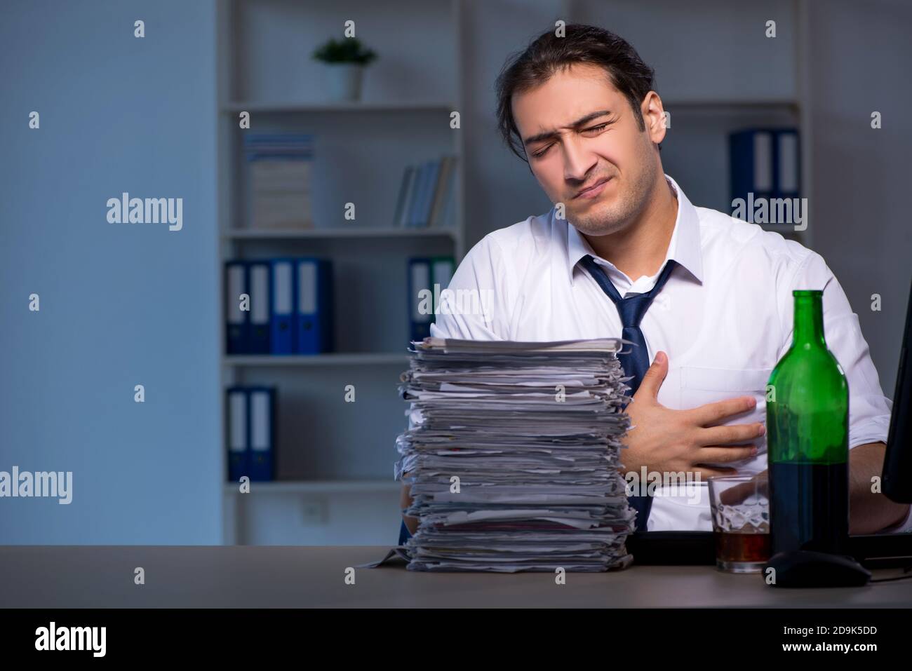 Alcohol addicted businessman working late Stock Photo - Alamy
