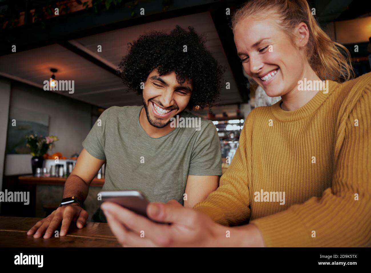 Friends laughing mobile device watching hi-res stock photography and ...