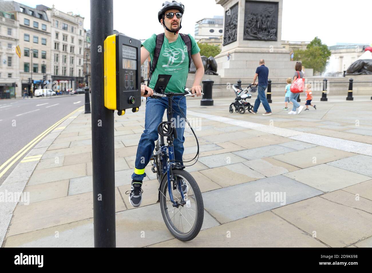 London, England, UK. Cyclist by a pedestrian crossing in Trafalgar ...