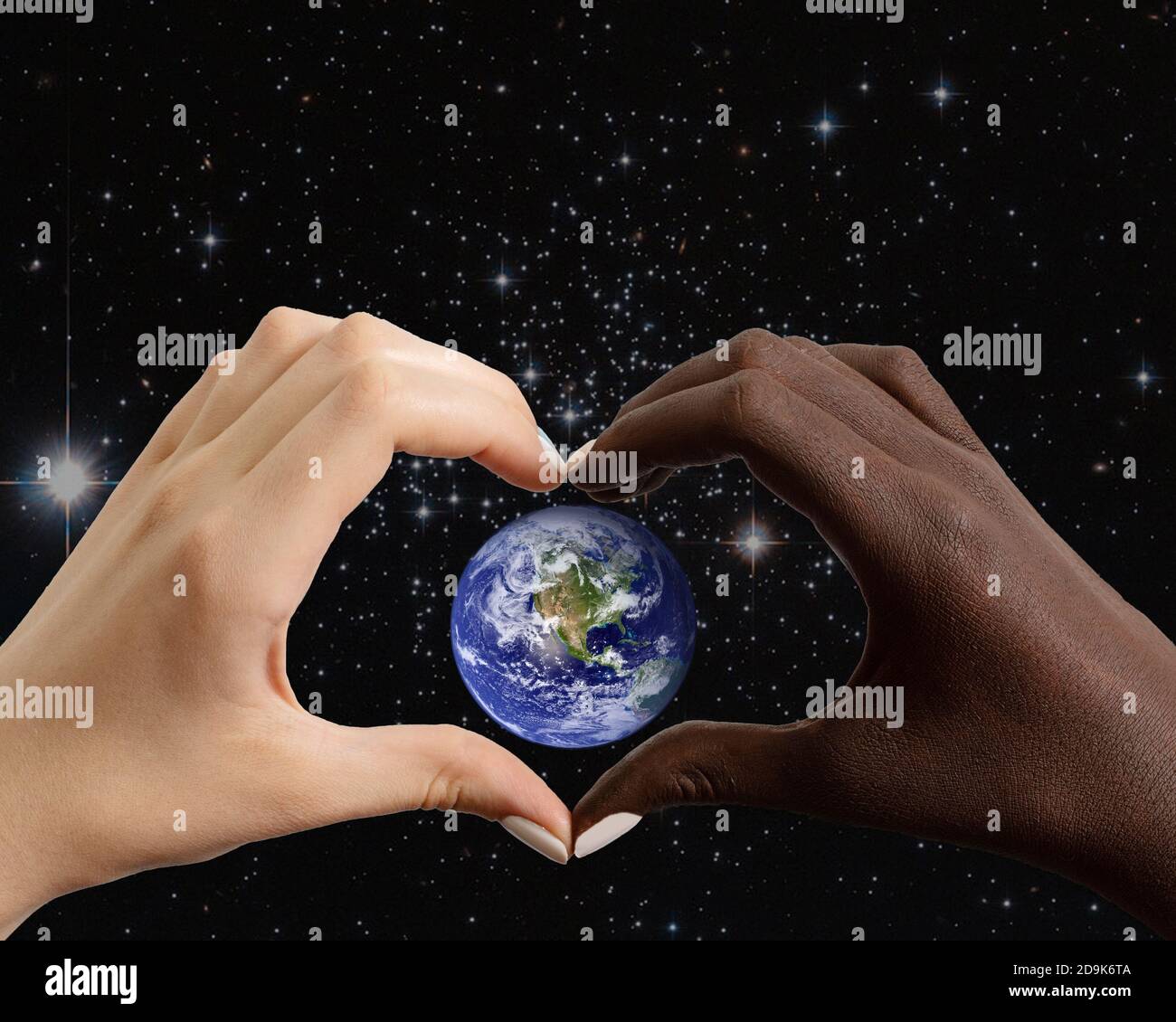 Black and white hands in the shape of a heart with the planet Earth on ...