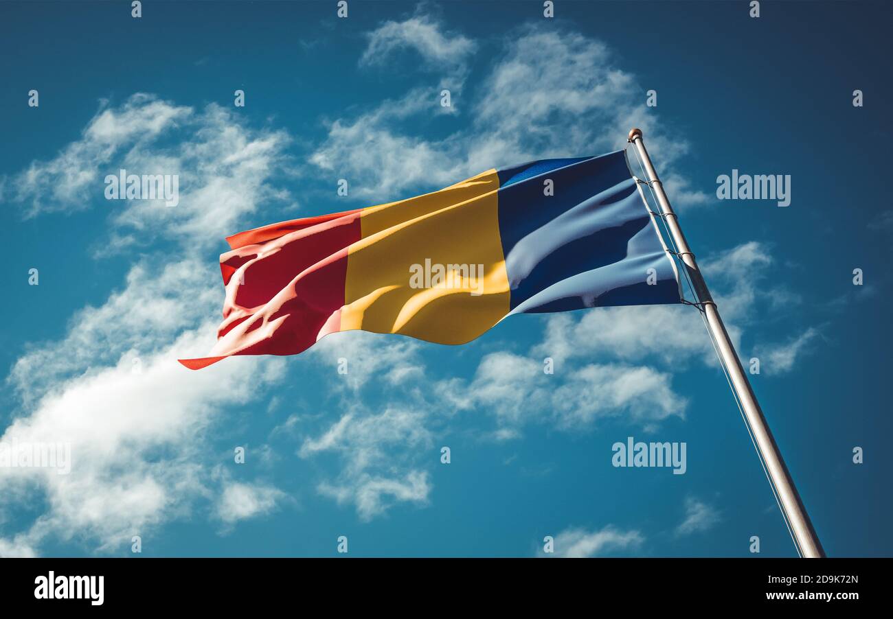 Beautiful national state flag of Romania fluttering at sky background ...