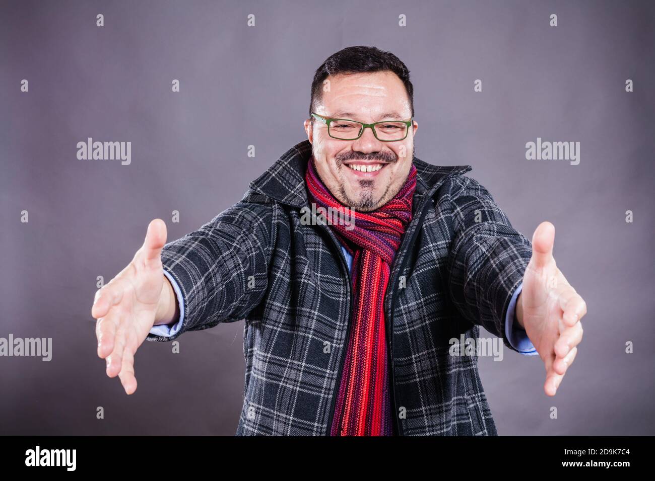 Solid cheerful man in coat and kerchief standing welcome emotional ...