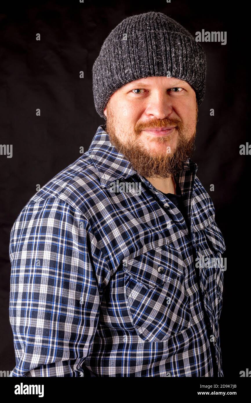 Solid bearded man in a wool cap portrait on black background Stock ...