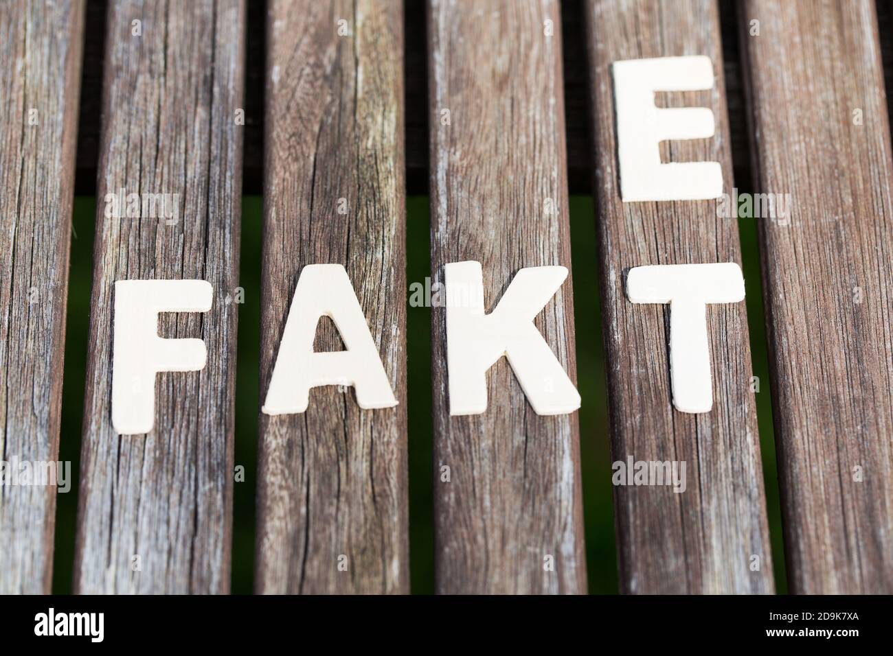 Fake, fact, as text, letters on wood Stock Photo - Alamy