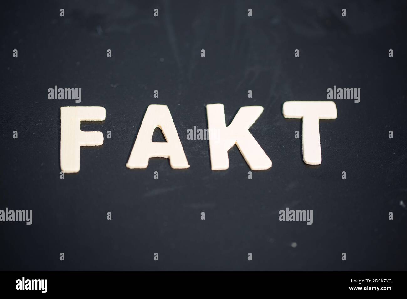 Fake, fact, as text, letters on wood, black background Stock Photo - Alamy