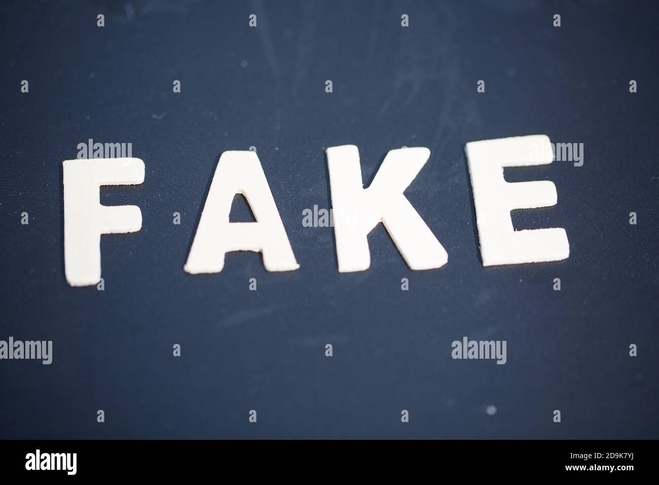 Fake, fact, as text, letters on wood, black background Stock Photo - Alamy