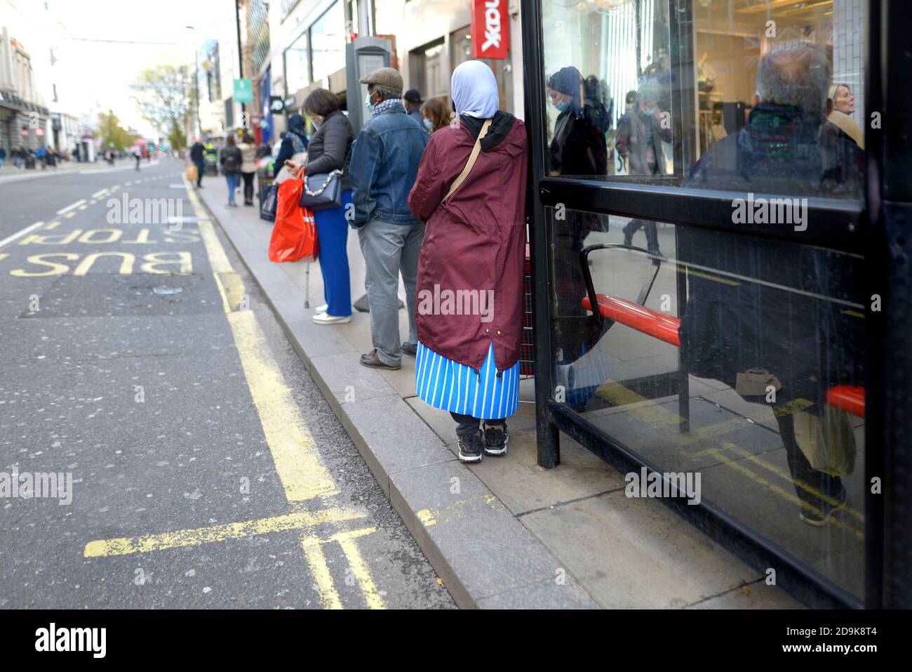 London, England, UK. People waiting at a bus stop in Oxford Street ...