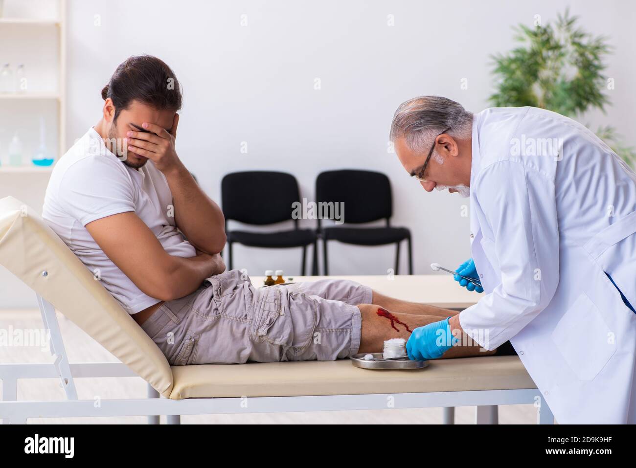 Leg injured man visiting doctor in first aid concept Stock Photo - Alamy