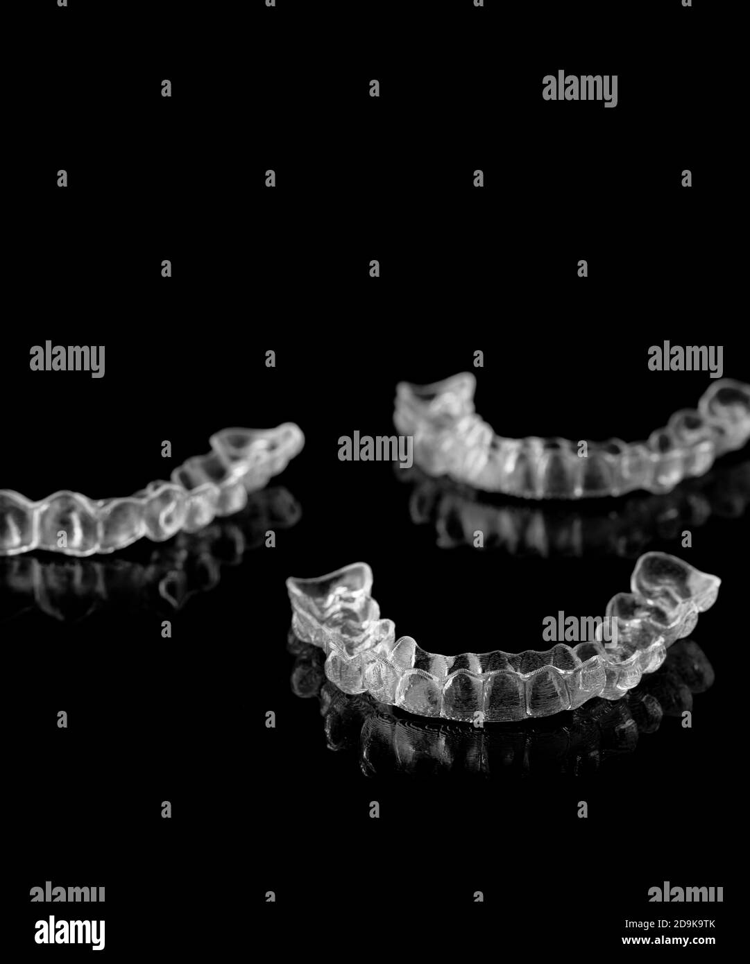 Invisible orthodontics cosmetic brackets on black background, tooth ...