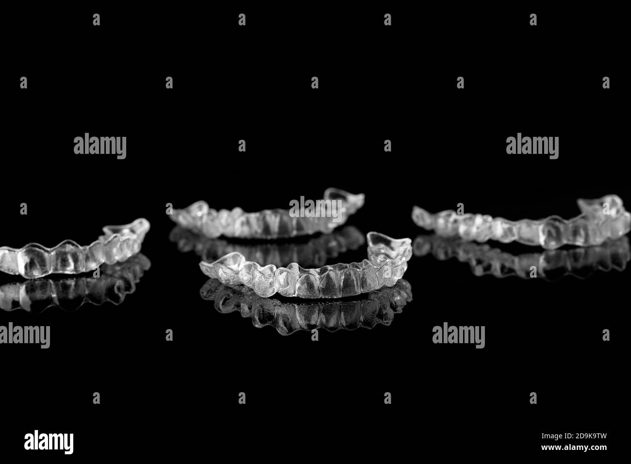 Invisible orthodontics cosmetic brackets on black background, tooth ...
