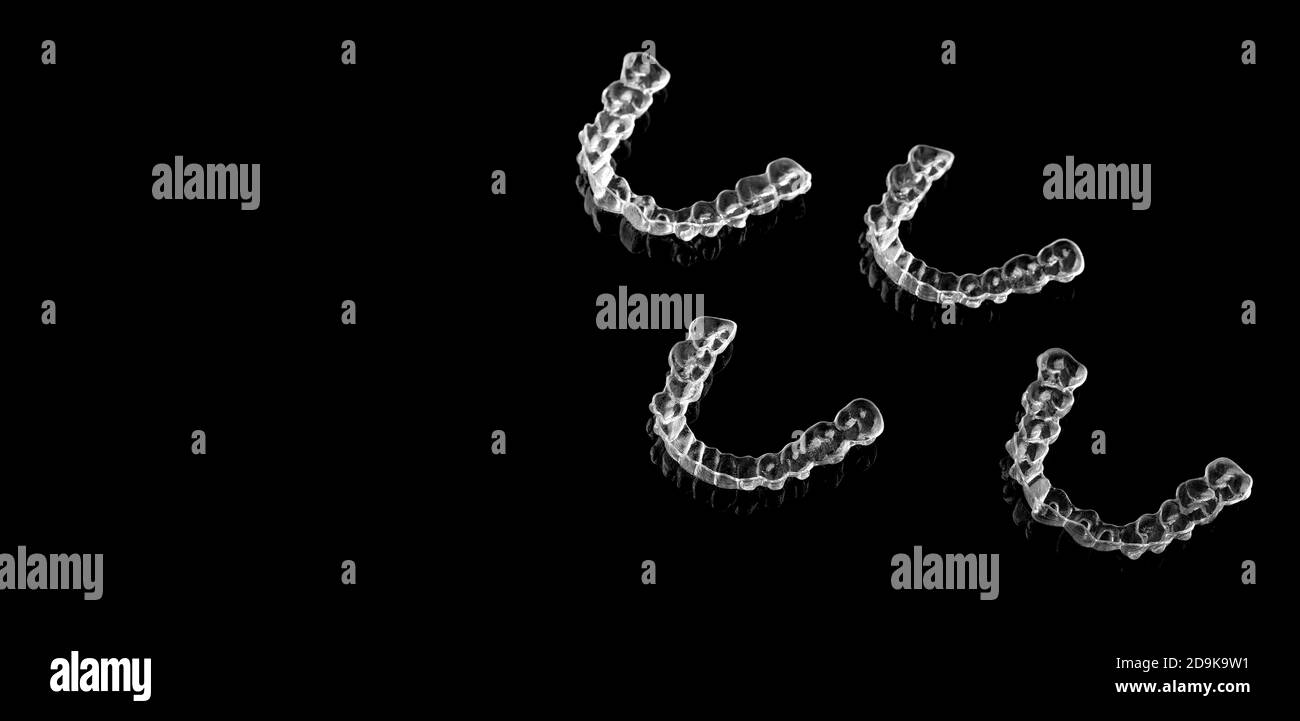 Invisible orthodontics cosmetic brackets on black background, tooth ...