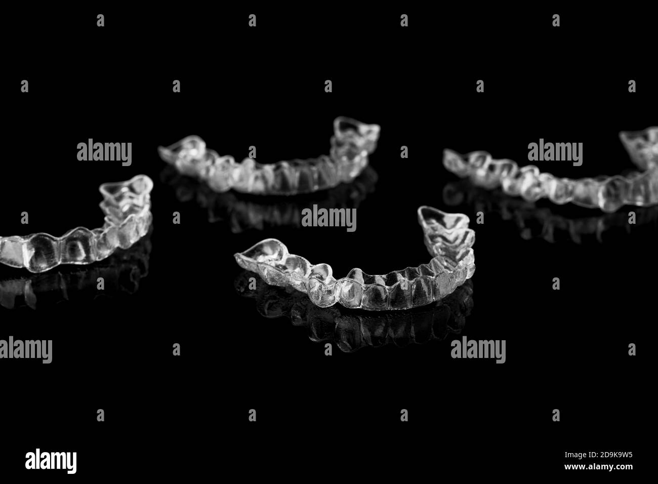 Invisible orthodontics cosmetic brackets on black background, tooth ...