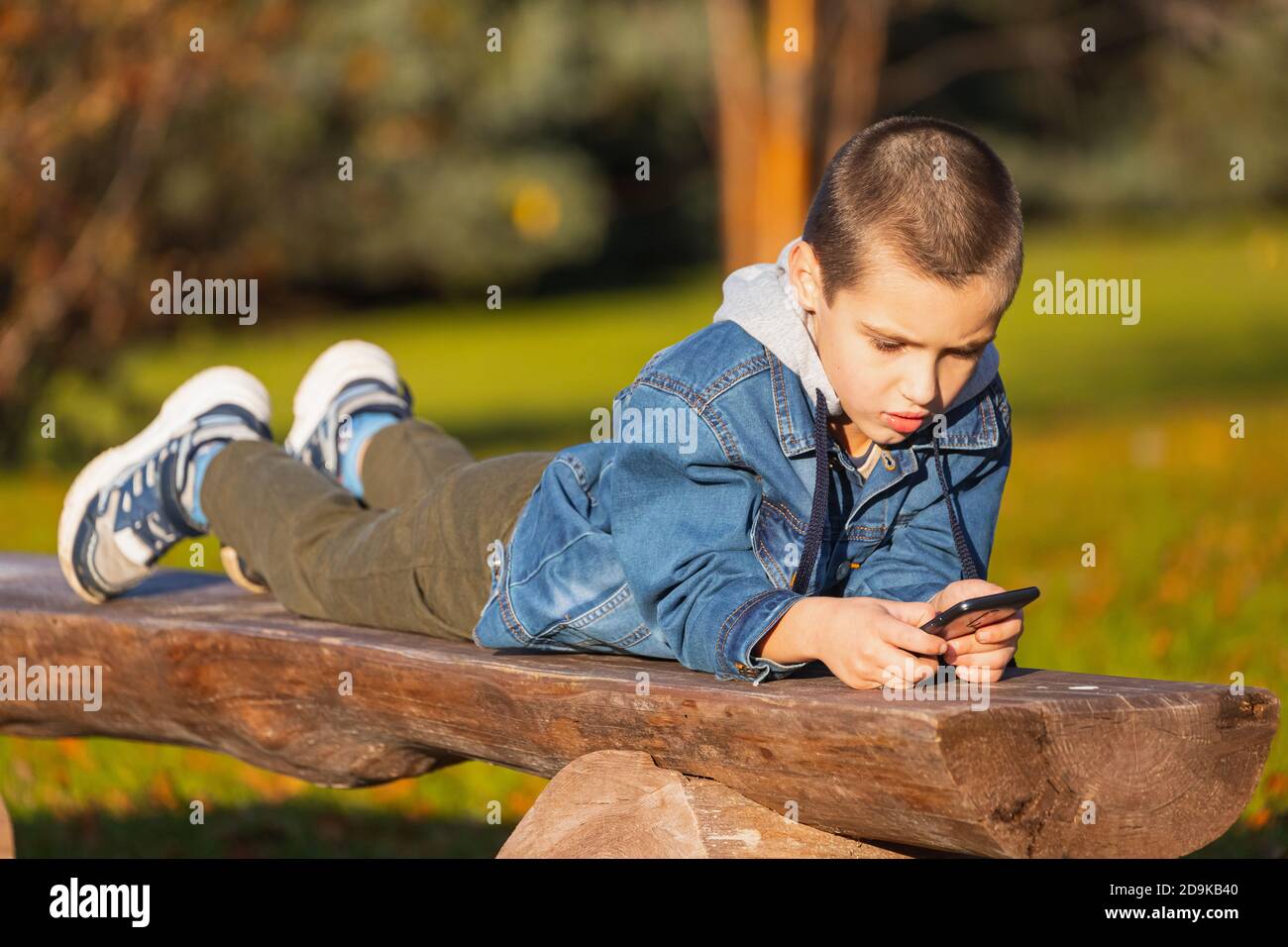 Little boy child playing mobile games on smartphone in the park. Funny ...